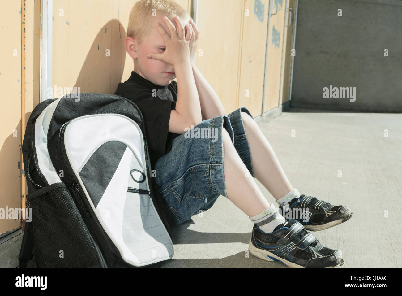 A very sad boy in school playground Stock Photo - Alamy