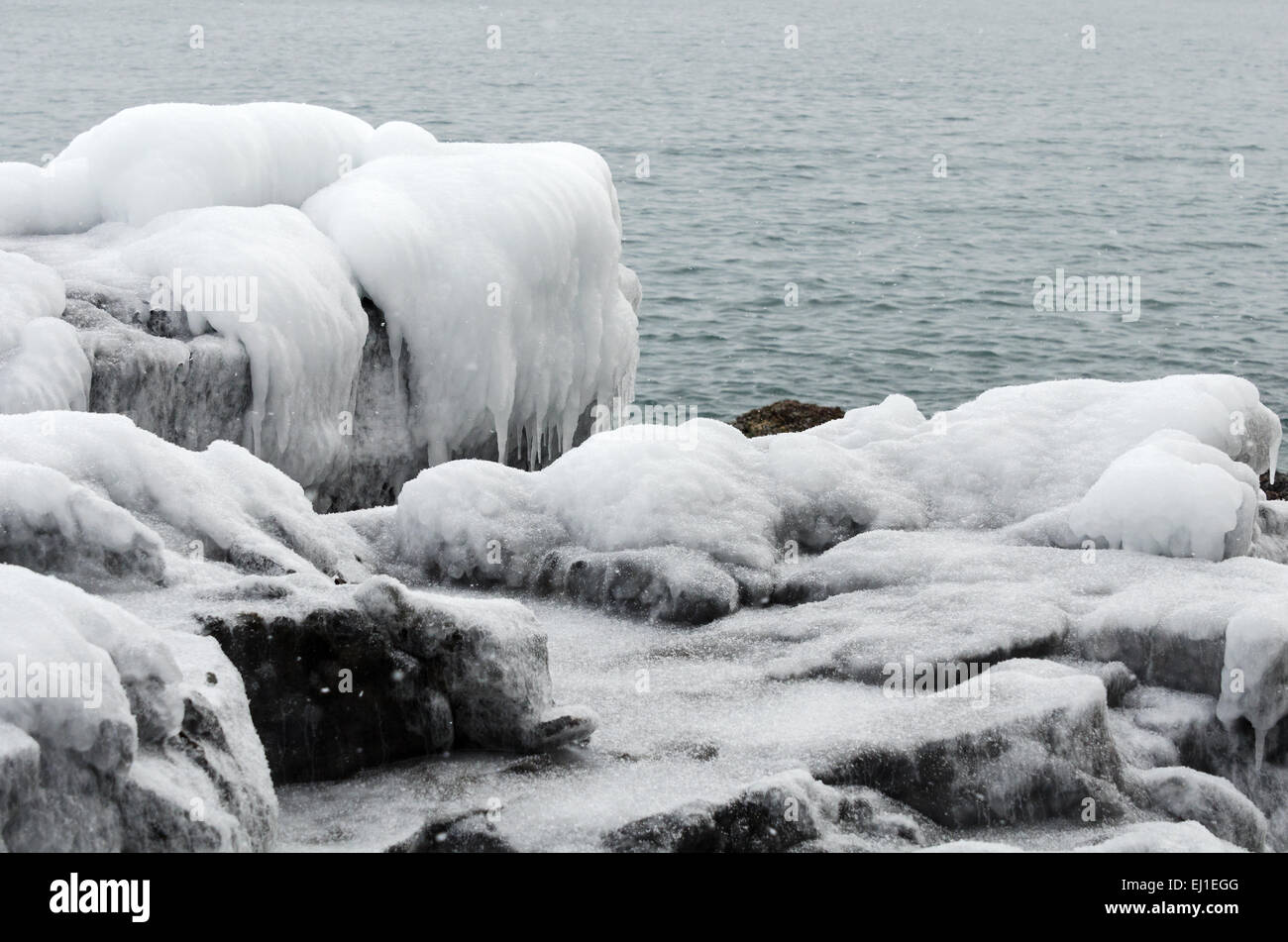 Sea ice covers ledges exposed by low tide during a snowstorm in Acadia ...