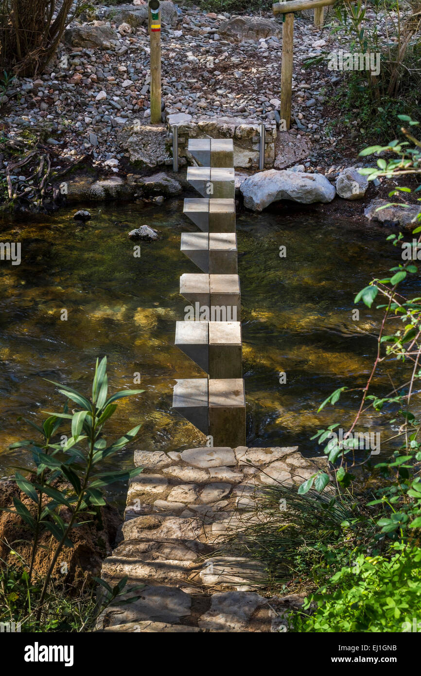 View of step-by-step passage through a stream of water in the forest ...