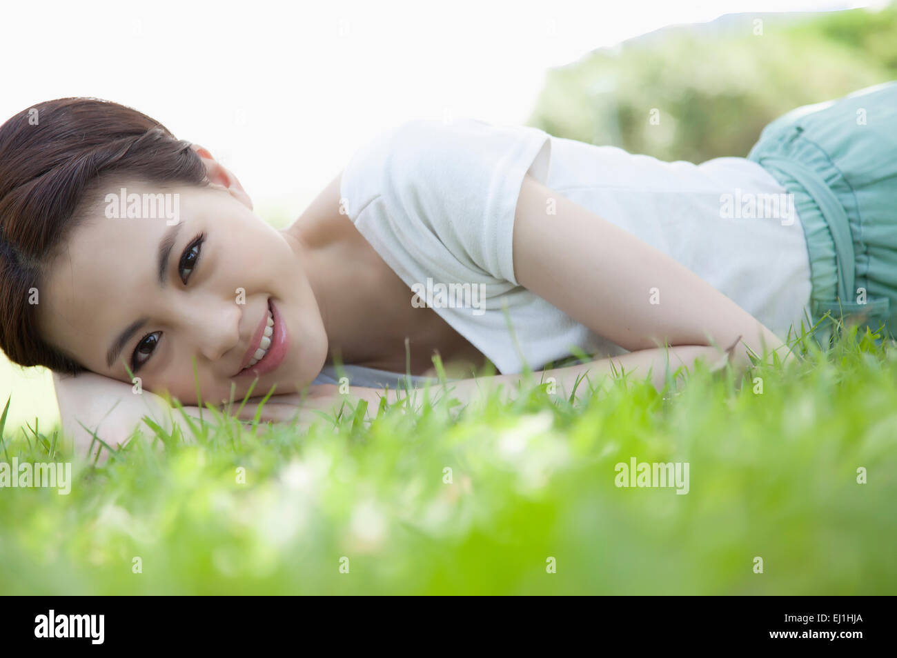 Young woman lying down on front and smiling at the camera Stock Photo ...