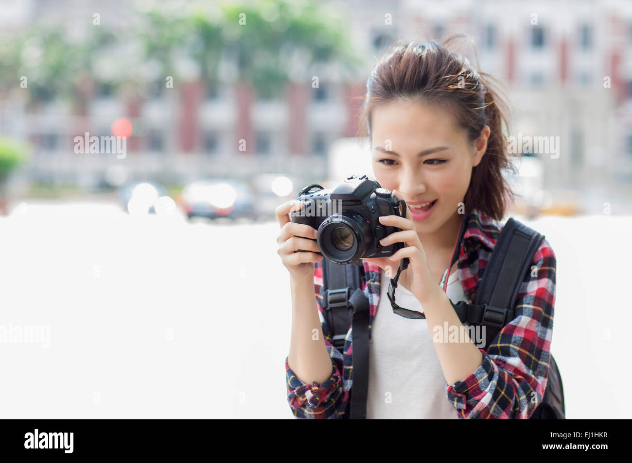 Young woman holding digital camera with smile Stock Photo - Alamy