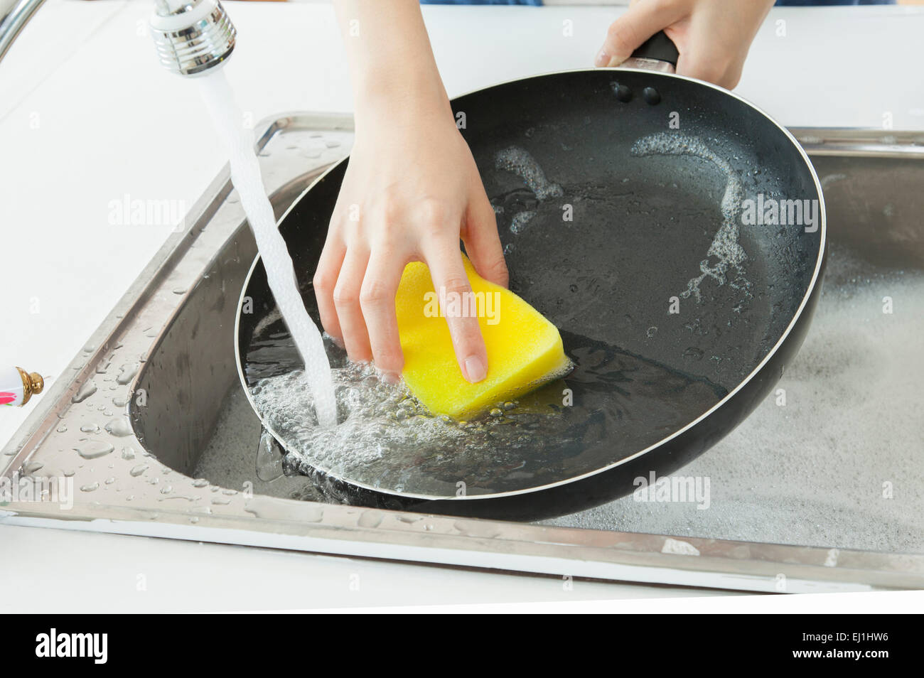 Human hands washing pans in the kitchen sink Stock Photo - Alamy
