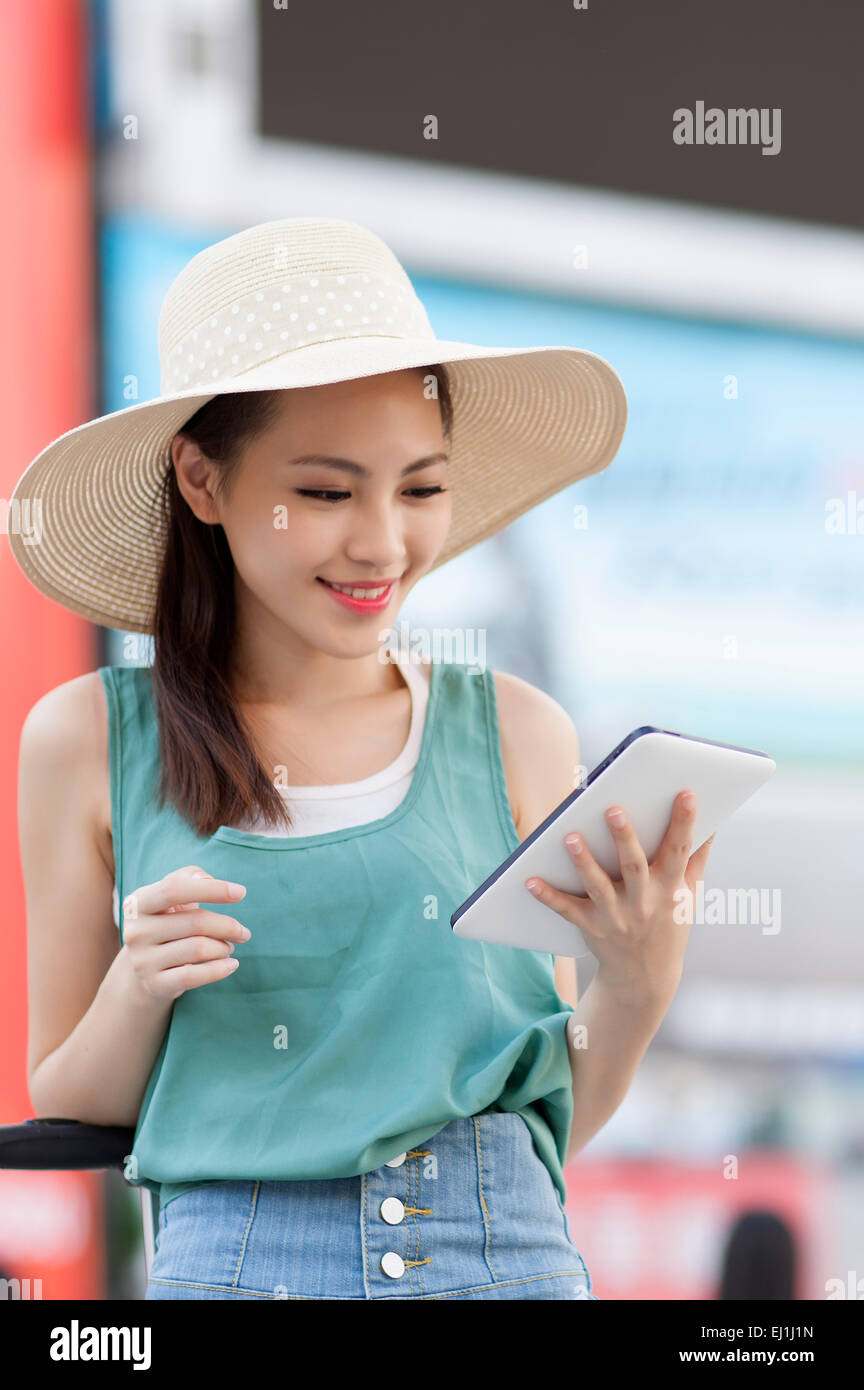Young woman holding touch pad and looking down with smile Stock Photo ...
