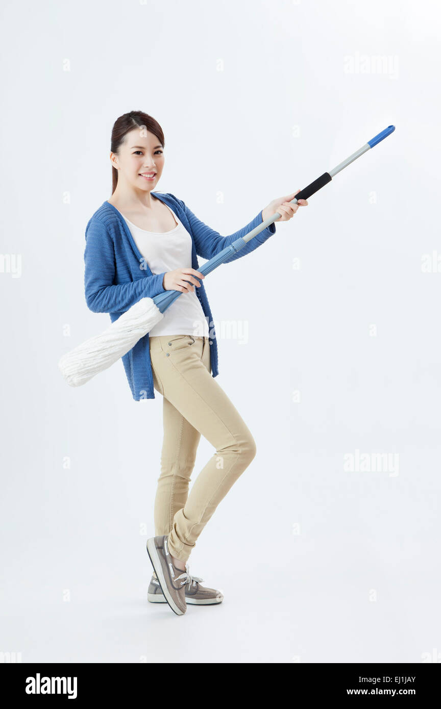 Young woman standing and holding a mop with smile Stock Photo - Alamy