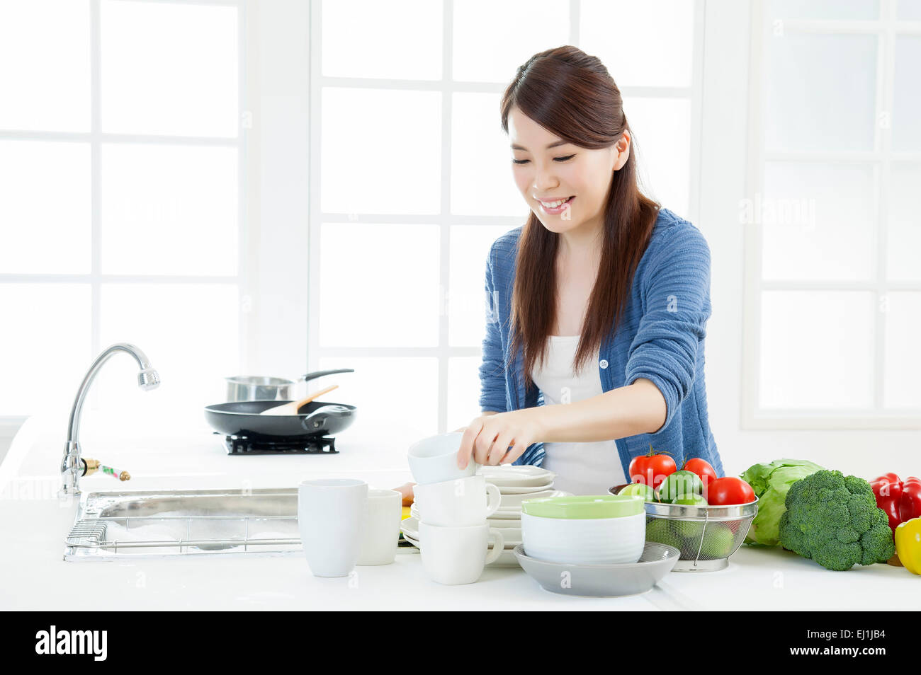 Young woman washing cups with smile Stock Photo - Alamy