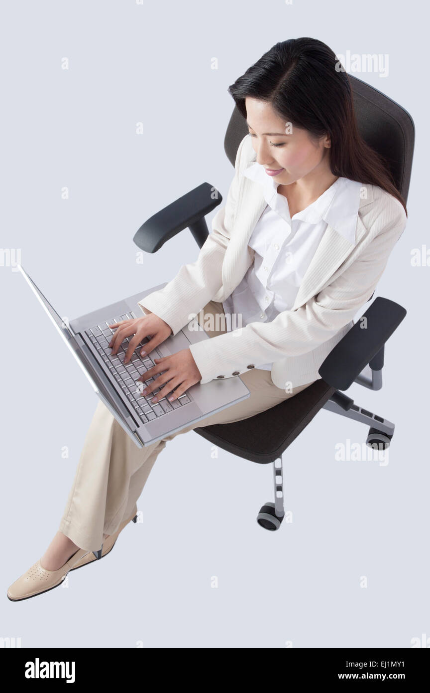 Young business woman sitting on chair and using laptop Stock Photo - Alamy