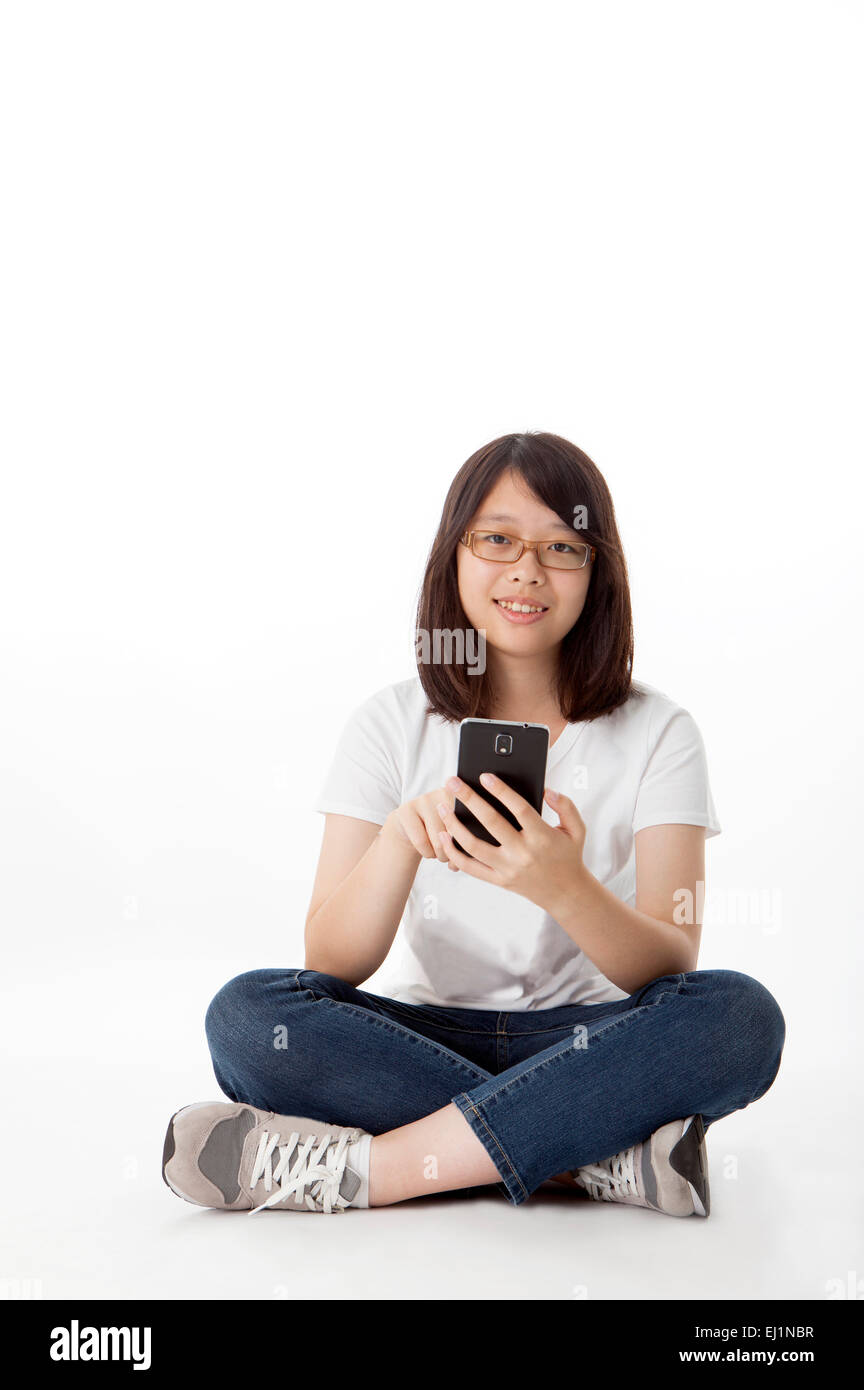 Teenage girl sitting and holding mobile phone with smile Stock Photo - Alamy