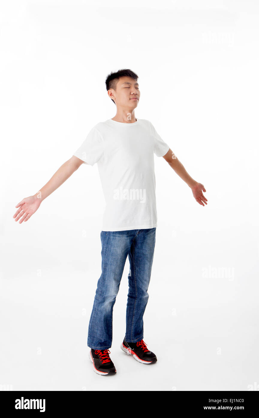 Teenage boy standing with arms outstretched Stock Photo - Alamy