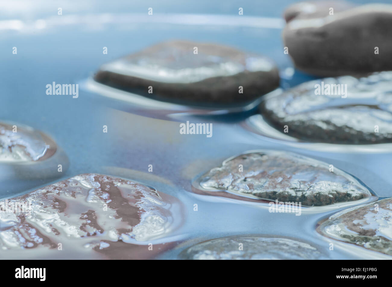pebbles stones in blue water Stock Photo - Alamy