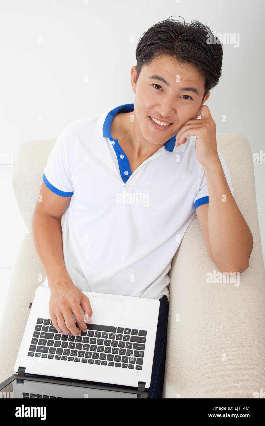 Man holding laptop and smiling at the camera Stock Photo - Alamy