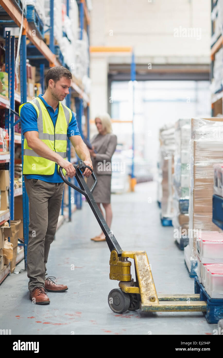 Worker pulling trolley with boxes Stock Photo - Alamy