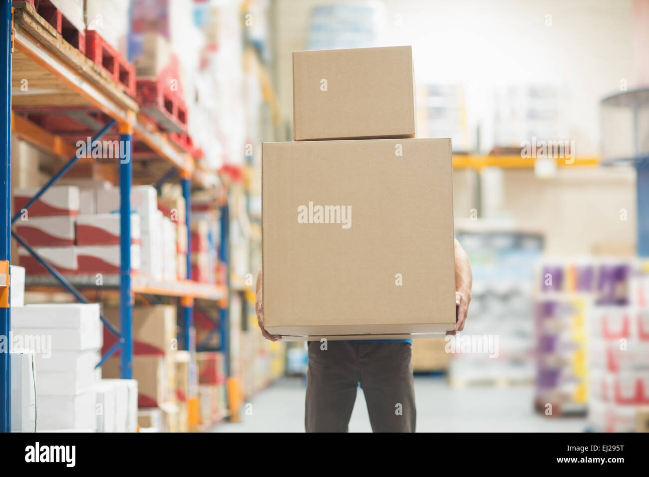 Worker carrying boxes in warehouse Stock Photo - Alamy
