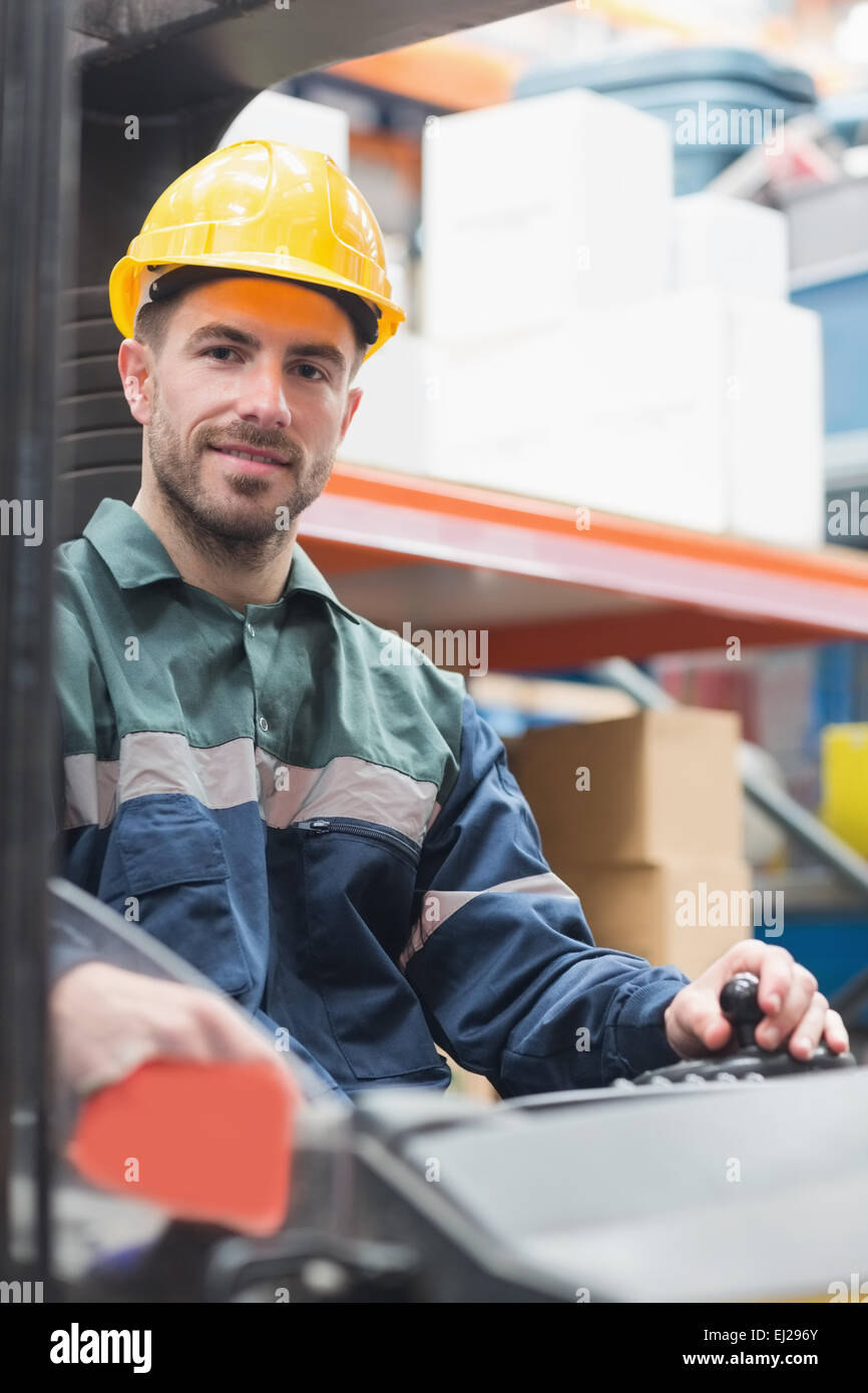 Driver operating forklift machine in warehouse Stock Photo - Alamy