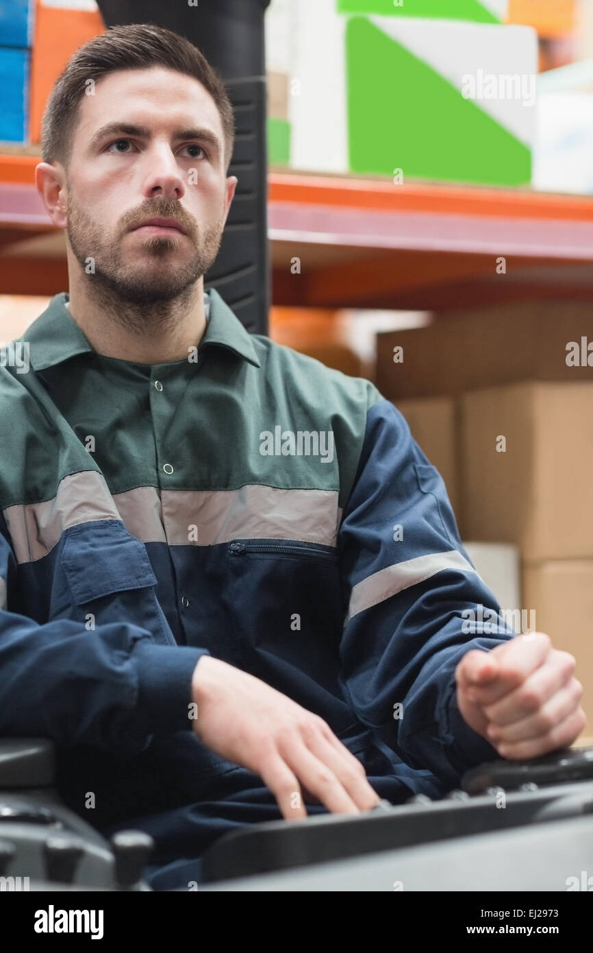 Focused driver operating forklift machine in warehouse Stock Photo - Alamy