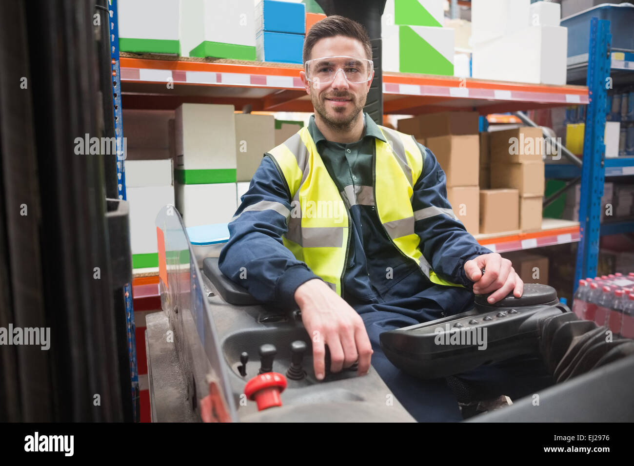 Smiling driver operating forklift machine Stock Photo - Alamy