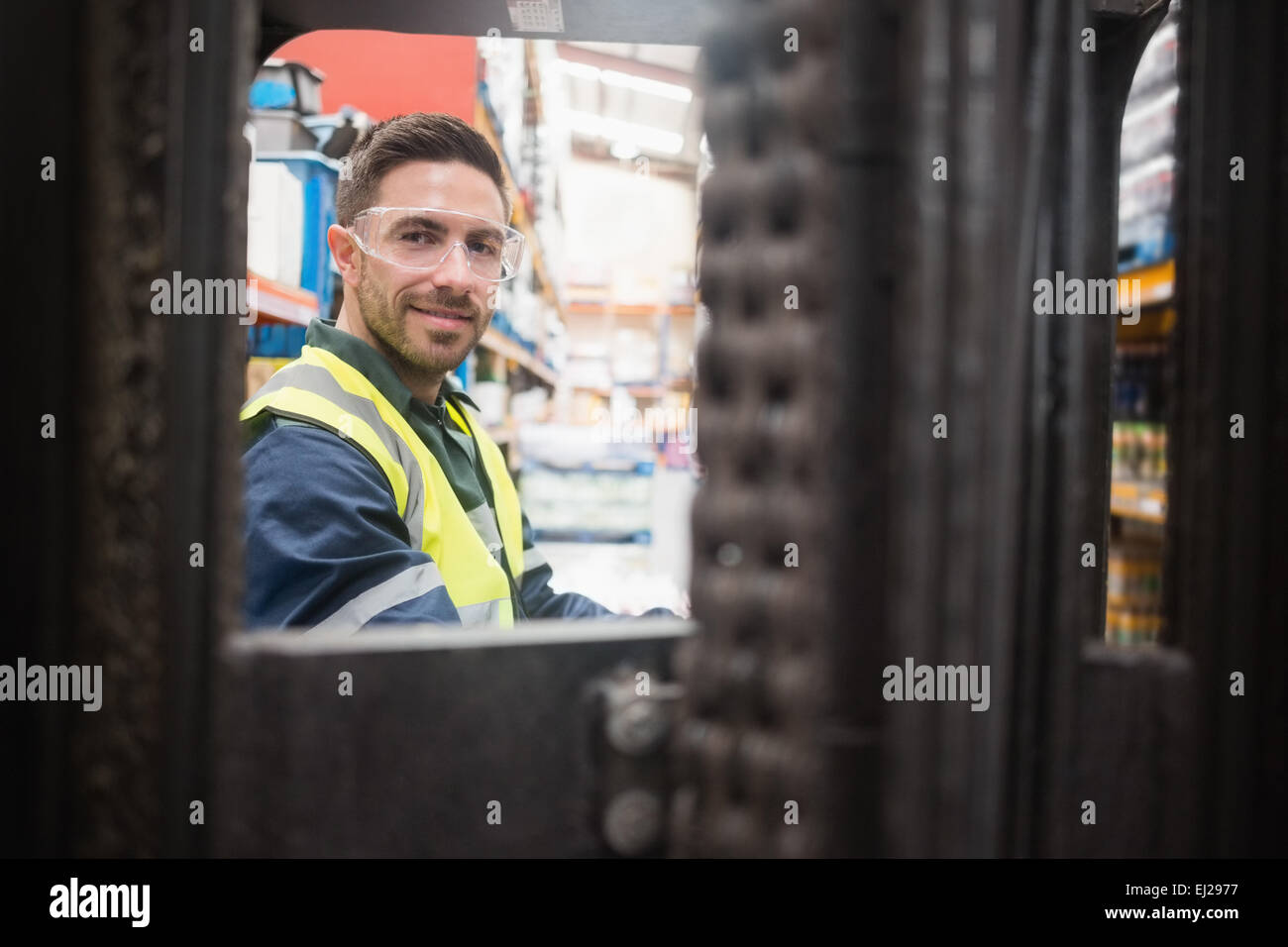 Smiling driver operating forklift machine Stock Photo - Alamy