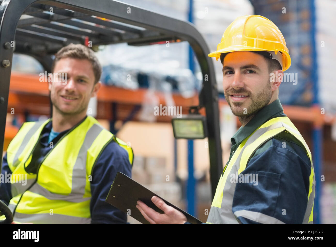 Smiling warehouse worker and forklift driver Stock Photo - Alamy