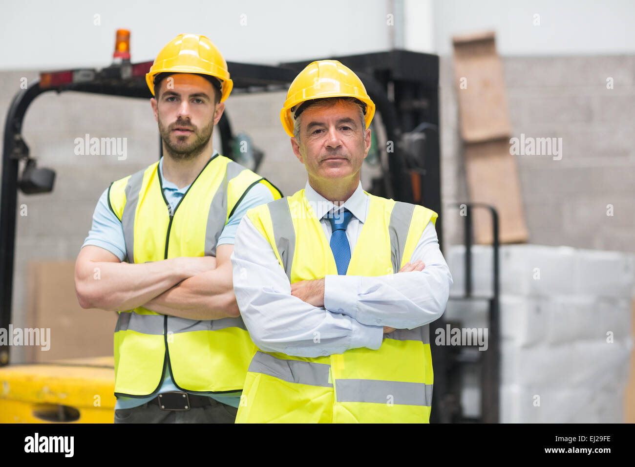 Manager with arms crossed and his colleague behind him Stock Photo - Alamy