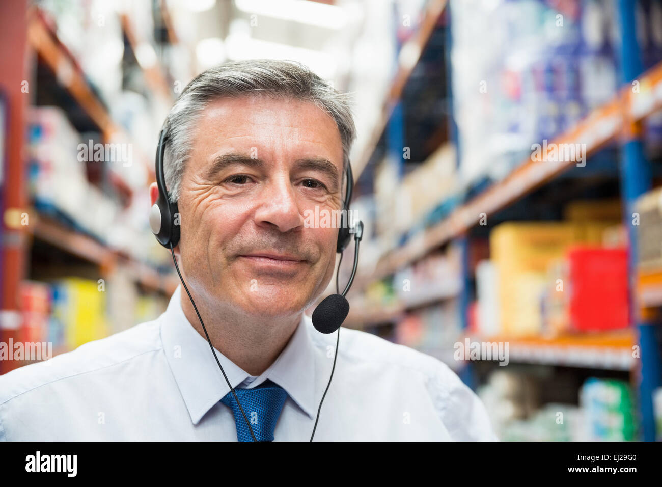 Warehouse manager giving orders on headset Stock Photo - Alamy