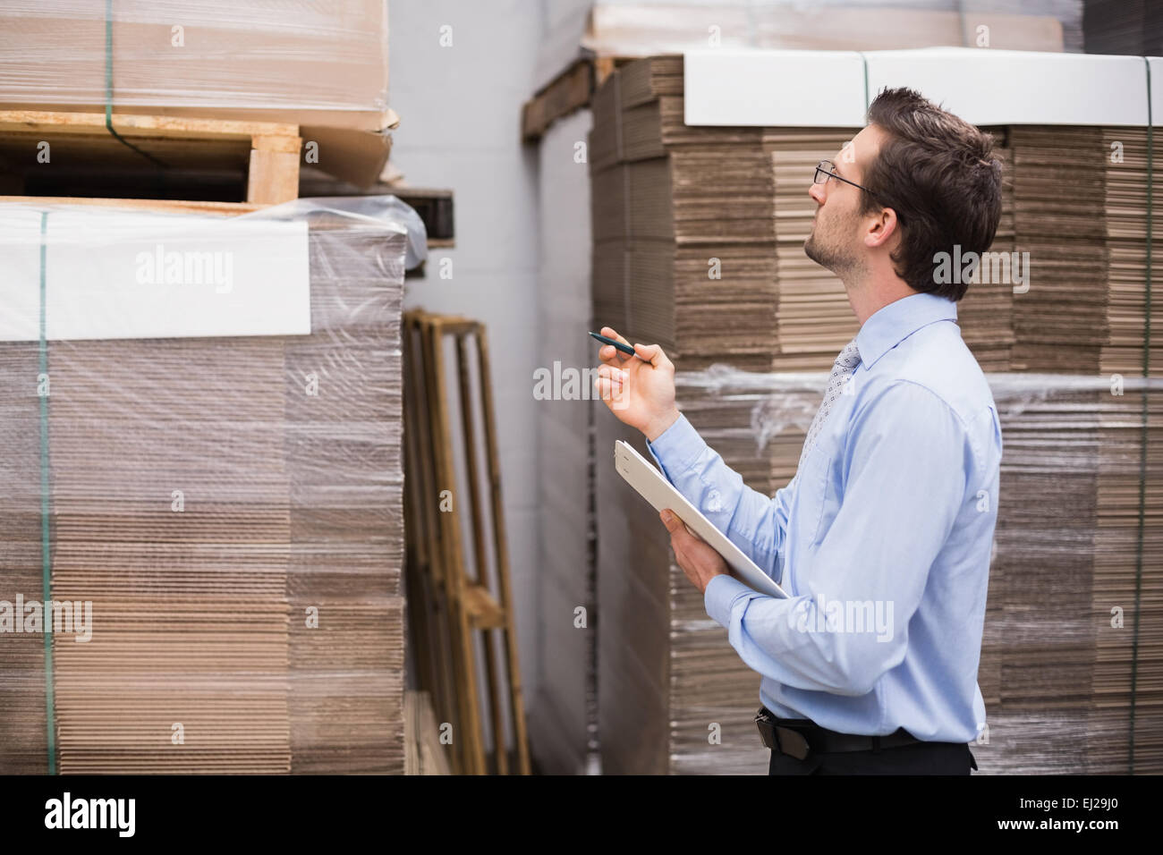 Warehouse manager checking his inventory Stock Photo - Alamy