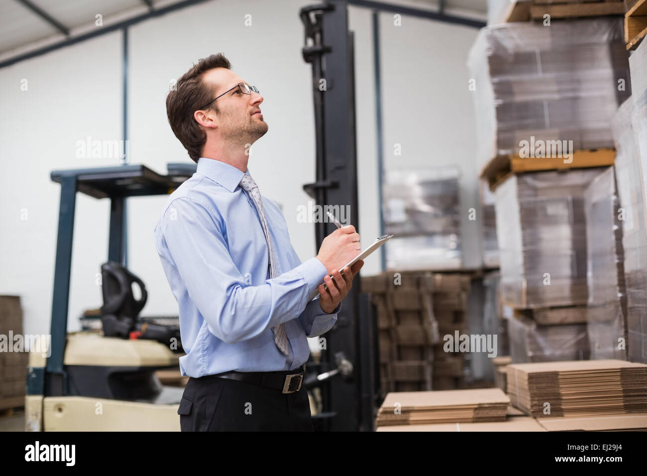 Warehouse manager checking his inventory Stock Photo - Alamy