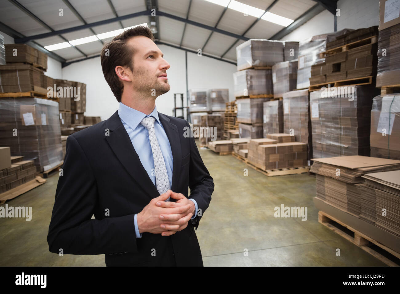 Warehouse manager standing hands together Stock Photo - Alamy