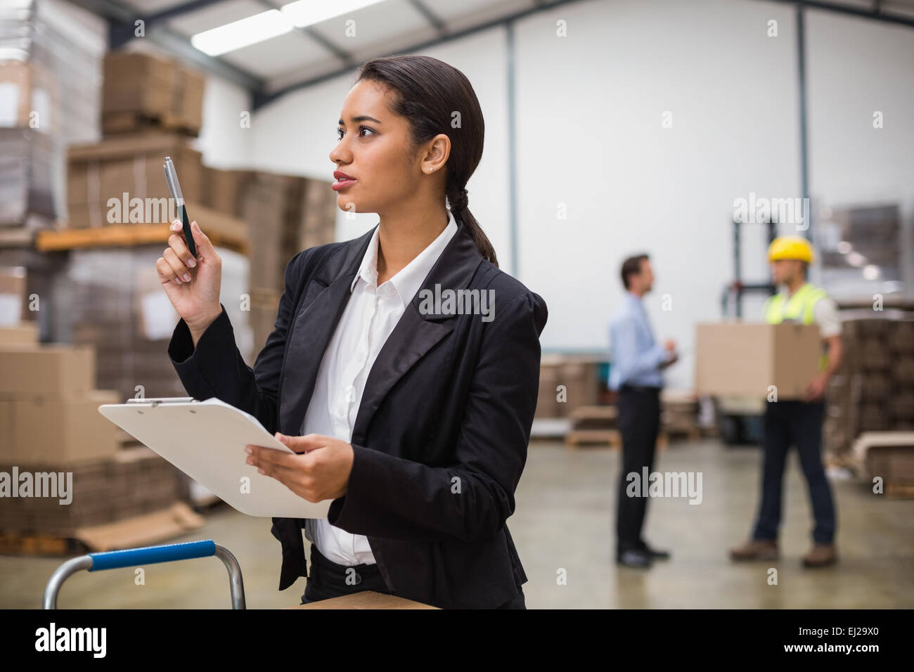 Pretty warehouse manager checking inventory Stock Photo - Alamy