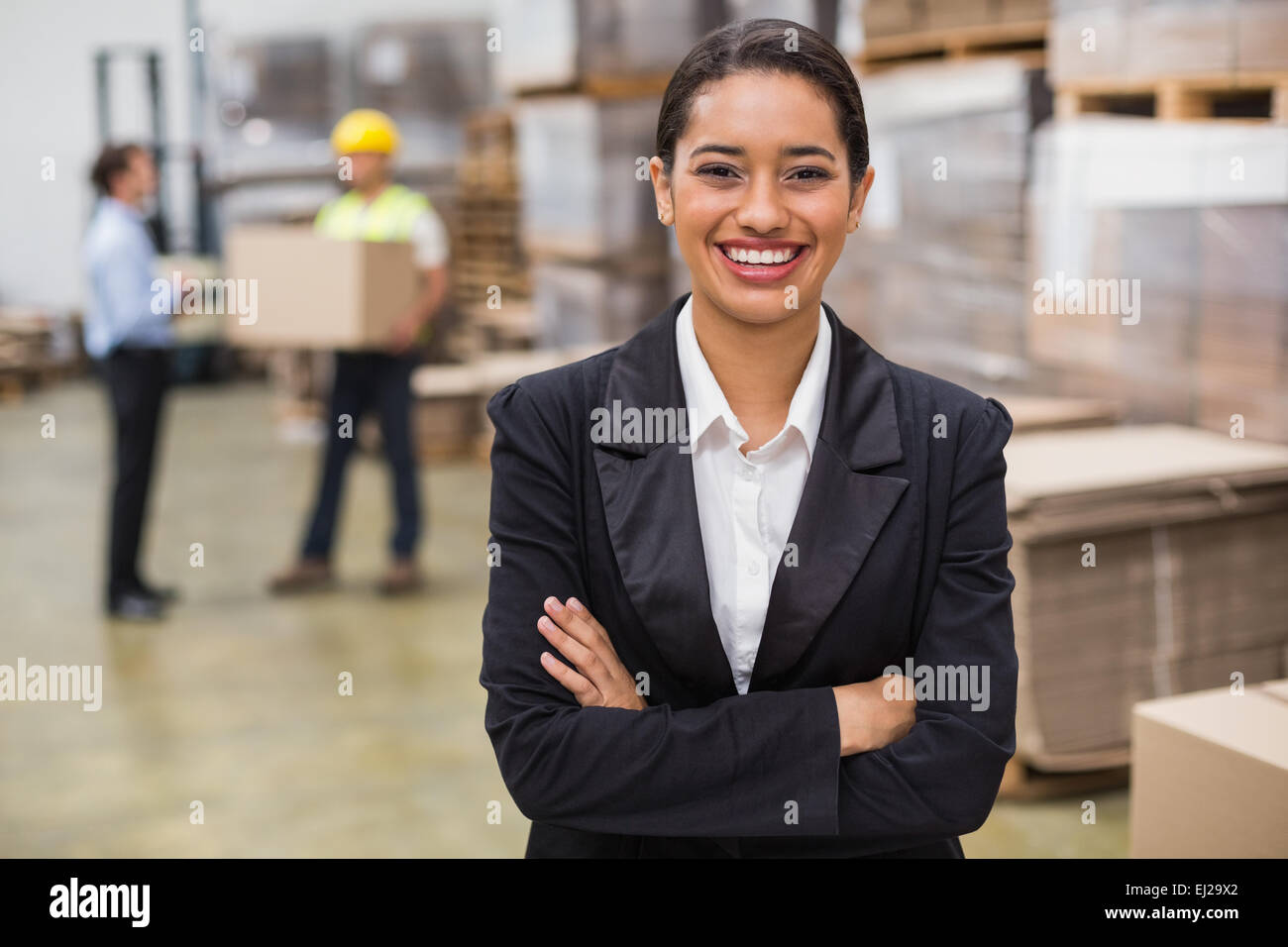 Female manager with arms crossed in warehouse Stock Photo - Alamy