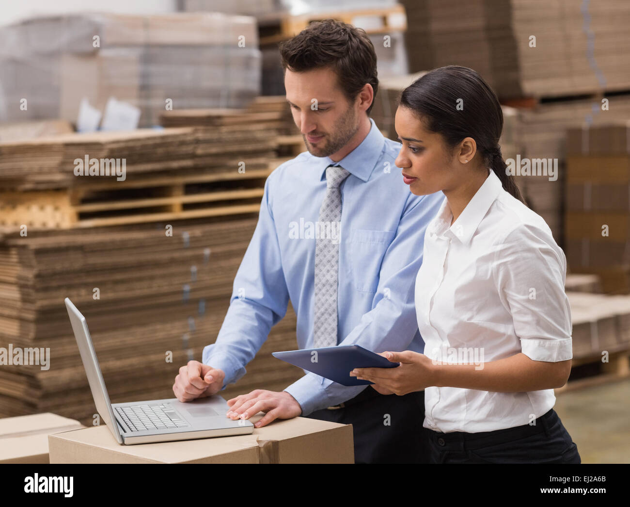 Warehouse managers working on laptop Stock Photo - Alamy