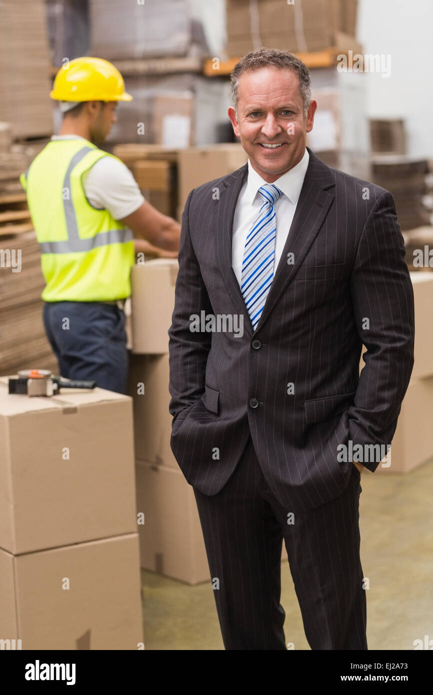 Smiling boss standing with hands in pockets Stock Photo - Alamy