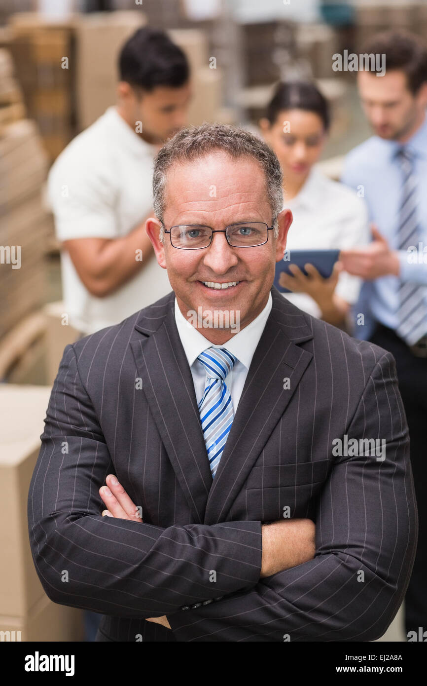 Boss wearing eyeglasses standing with arms crossed Stock Photo - Alamy