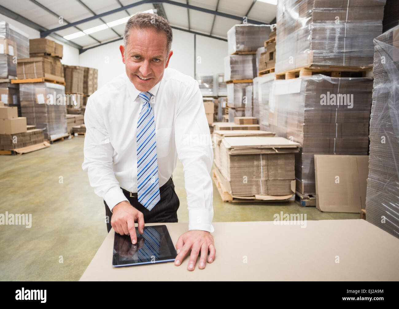 Smiling boss using tablet pc Stock Photo - Alamy