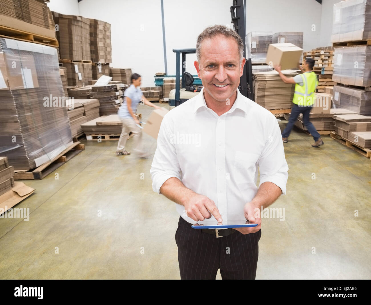 Manager using digital tablet during busy period Stock Photo - Alamy