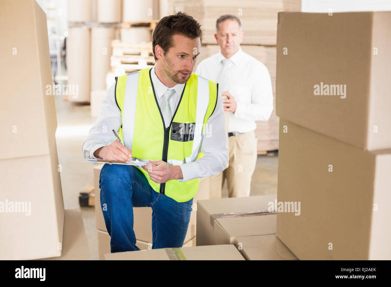 Delivery driver checking his list on clipboard Stock Photo - Alamy
