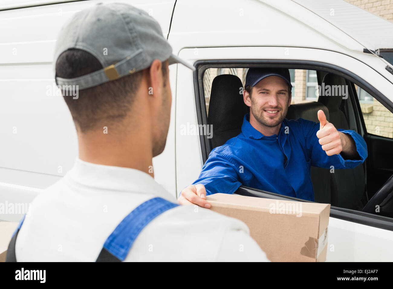 Delivery driver handing parcel to customer in his van Stock Photo - Alamy