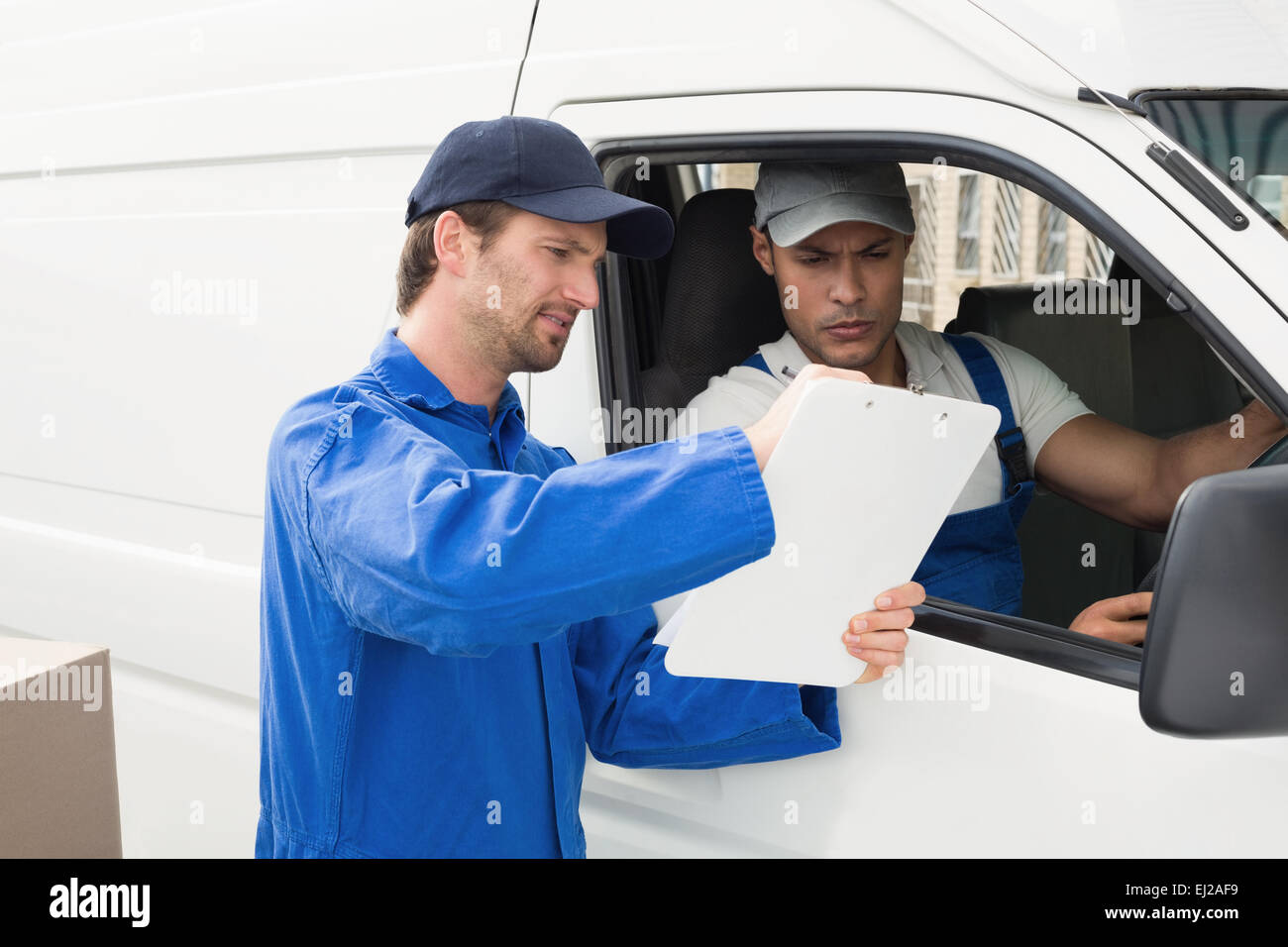 Delivery driver showing customer where to sign Stock Photo - Alamy