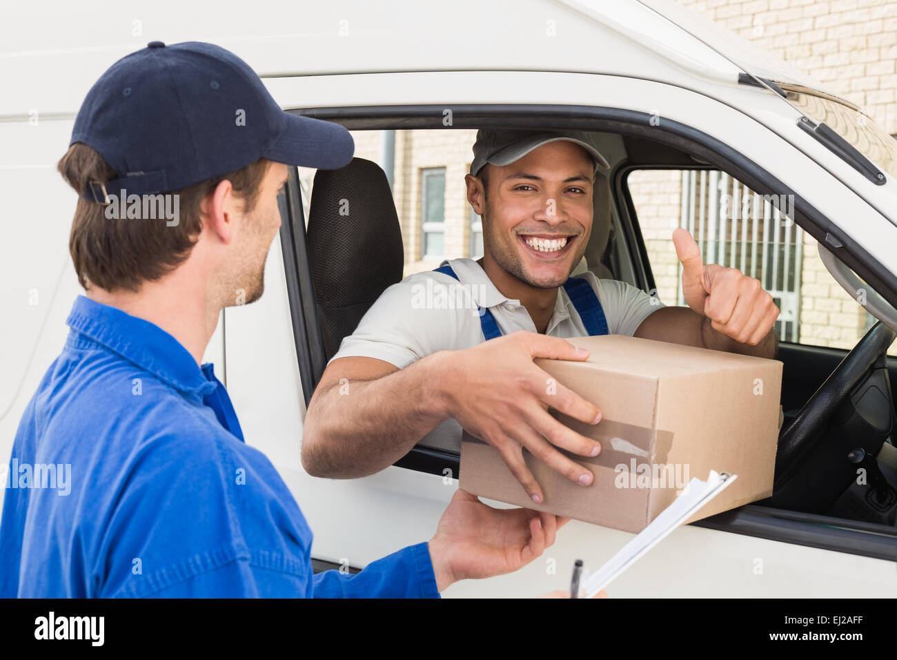 Delivery driver handing parcel to customer in his van Stock Photo - Alamy