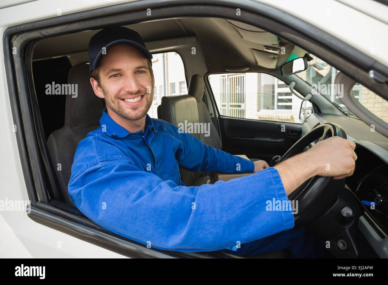 Delivery driver smiling at camera in his van Stock Photo - Alamy
