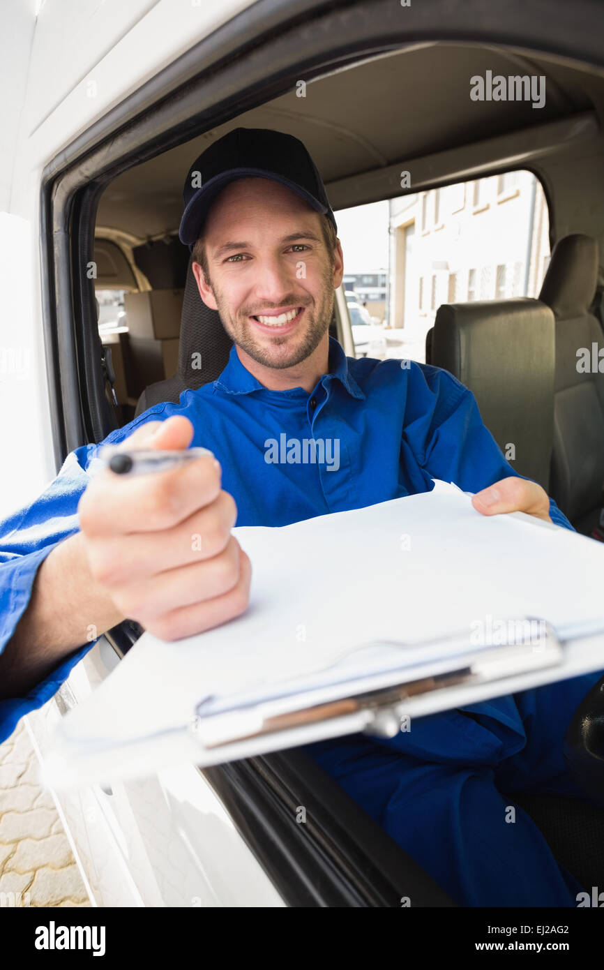 Happy delivery man showing clipboard to sign to customer Stock Photo ...