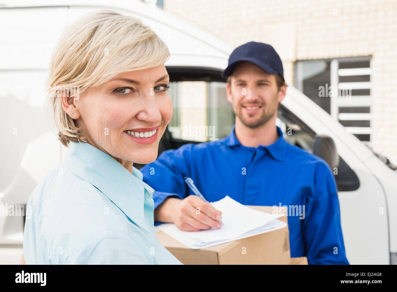 Happy delivery man with customer Stock Photo - Alamy