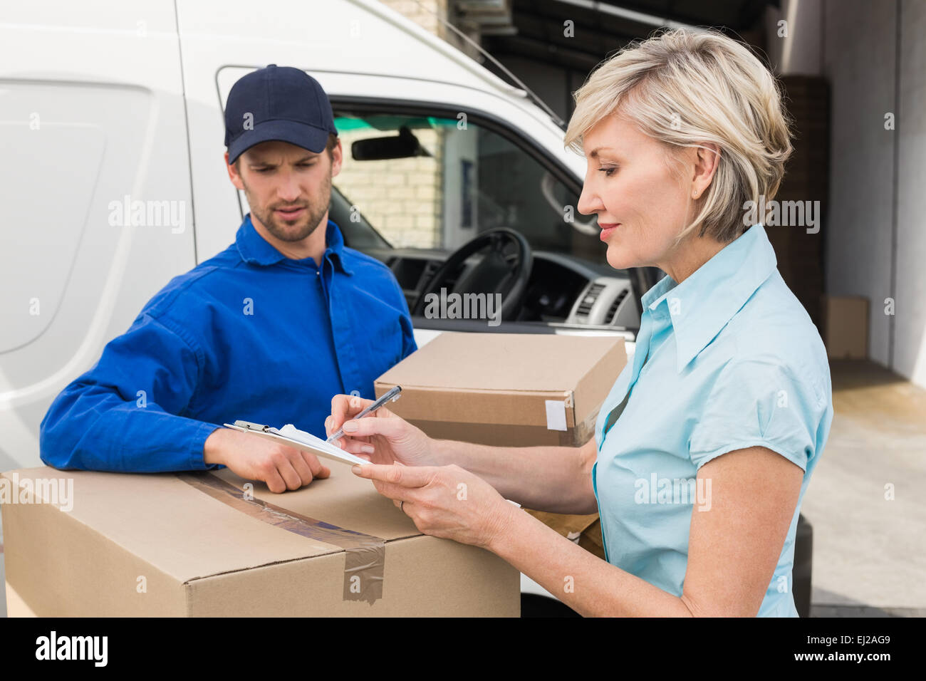 Happy delivery man with customer Stock Photo - Alamy