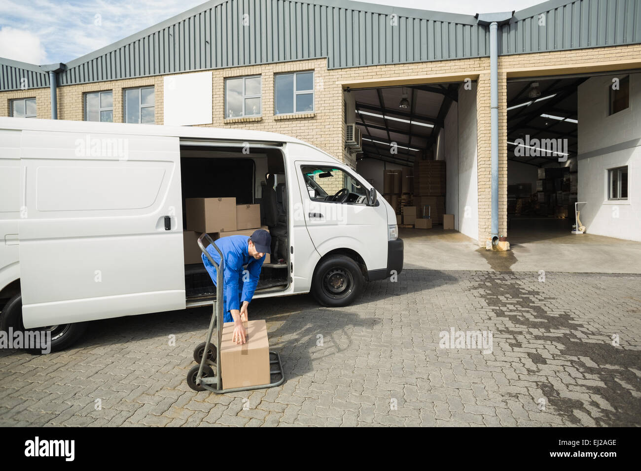 Delivery driver packing his van Stock Photo - Alamy