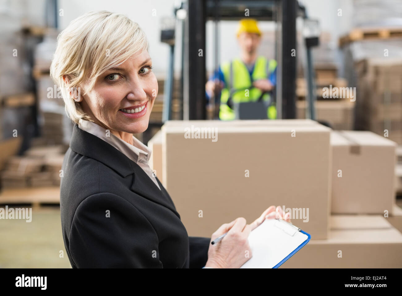 Warehouse manager writing on clipboard Stock Photo - Alamy