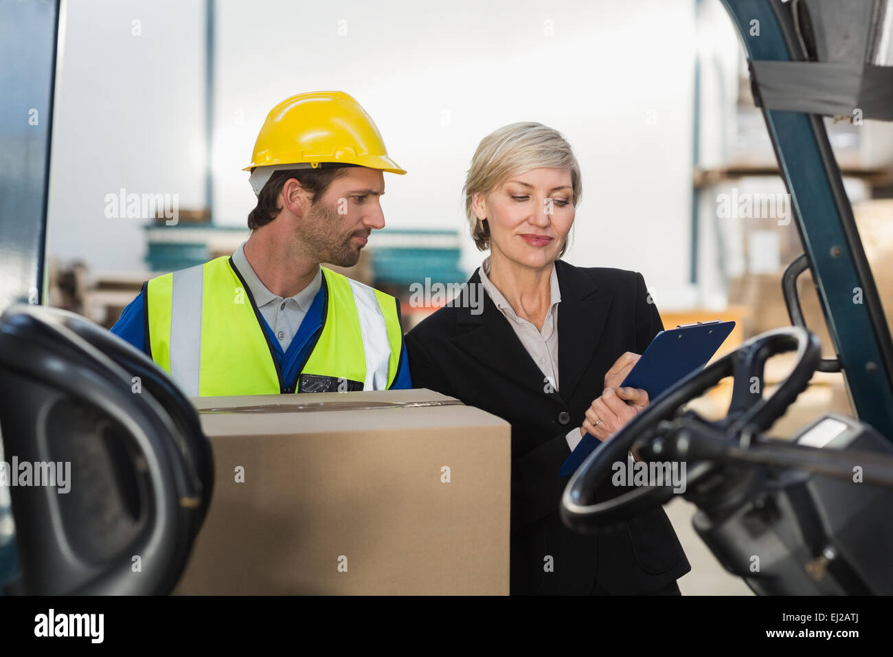 Warehouse manager talking with forklift driver Stock Photo - Alamy