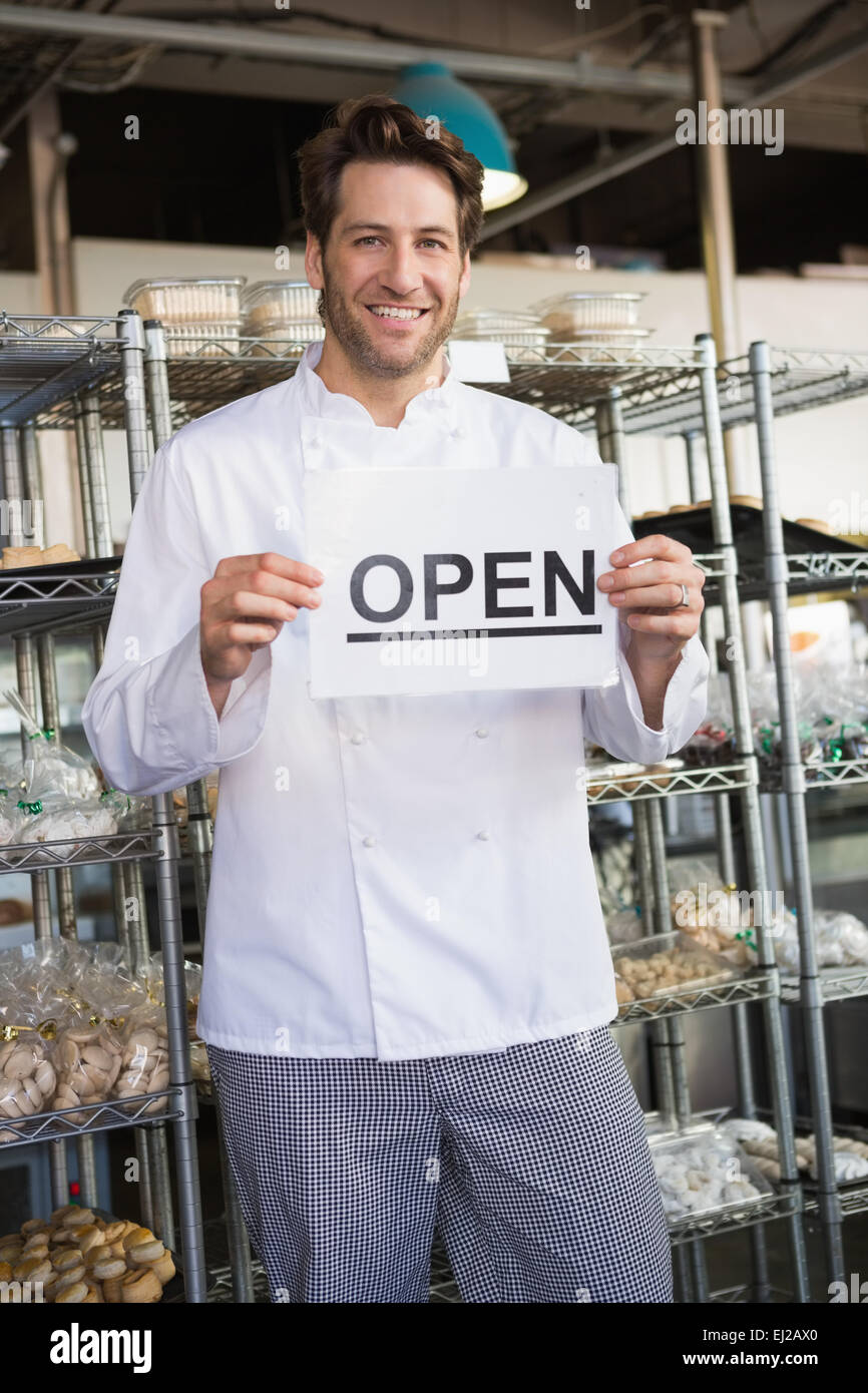 Portrait of a smiling baker holding open sign Stock Photo - Alamy