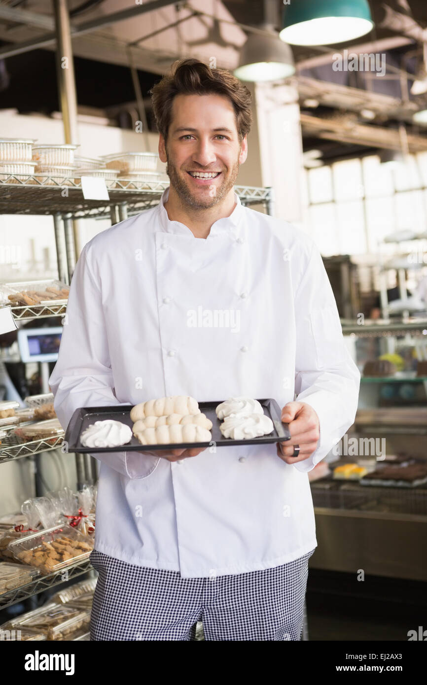 Smiling baker holding meringue tray Stock Photo - Alamy