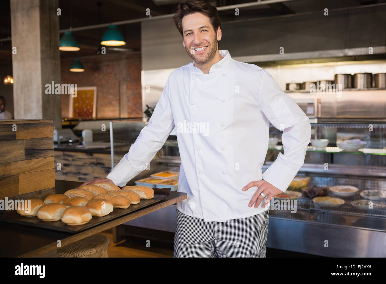 Smiling chef leaning on counter Stock Photo - Alamy
