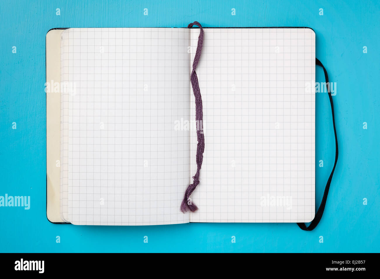 Open notebook on blue background Stock Photo - Alamy