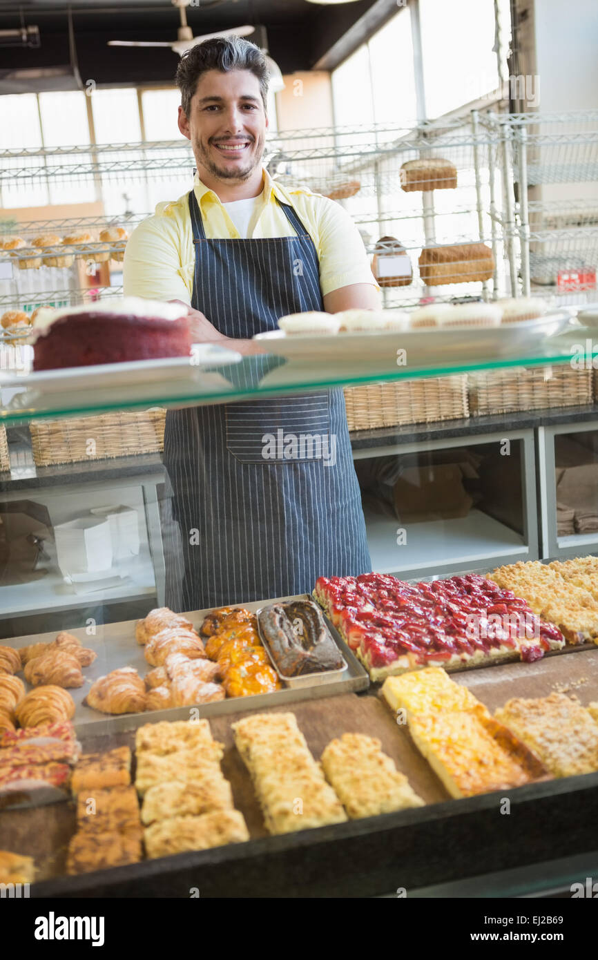 Smiling server standing with arms crossed behind the counter Stock ...