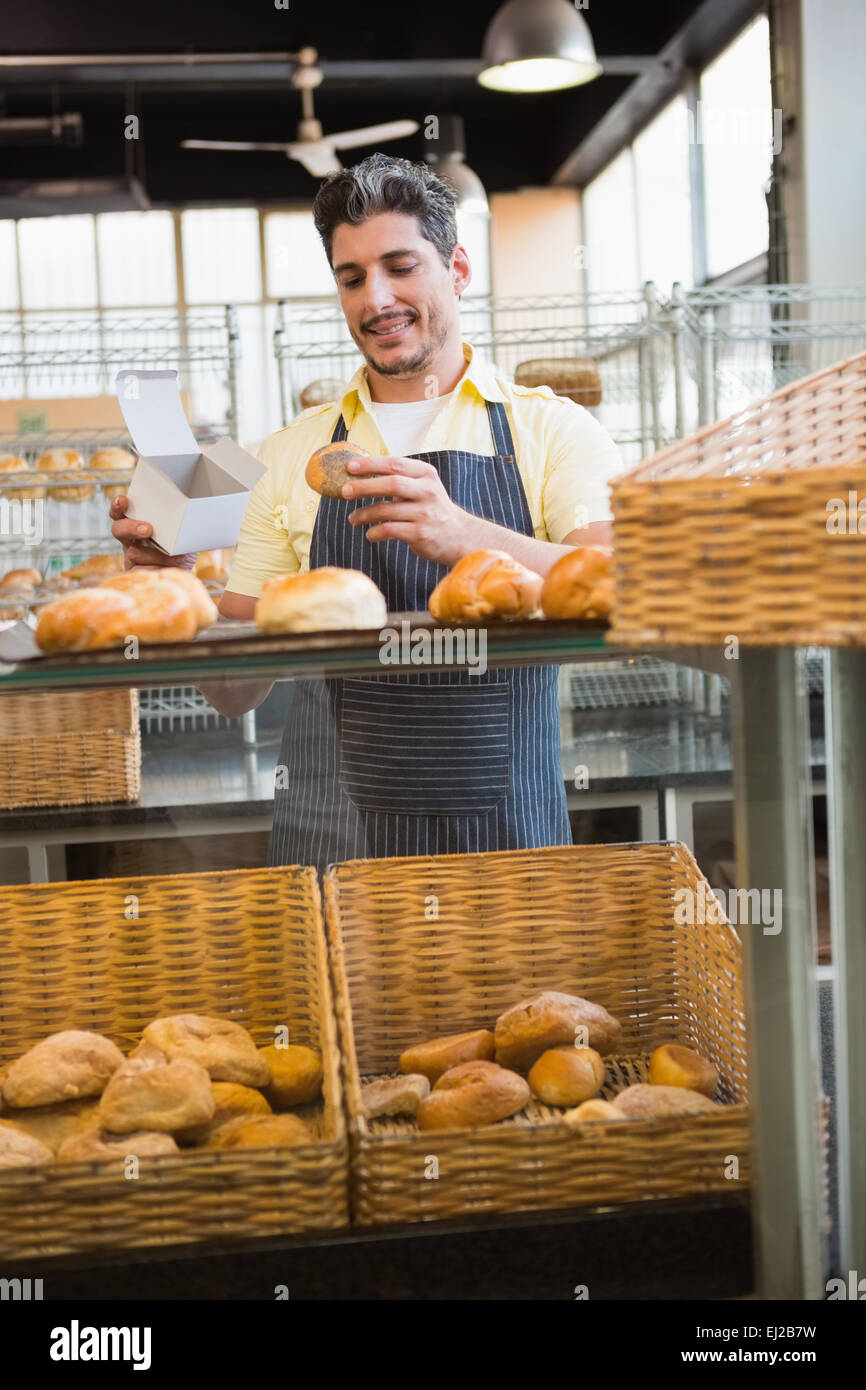 Smiling server holding bread and box Stock Photo - Alamy